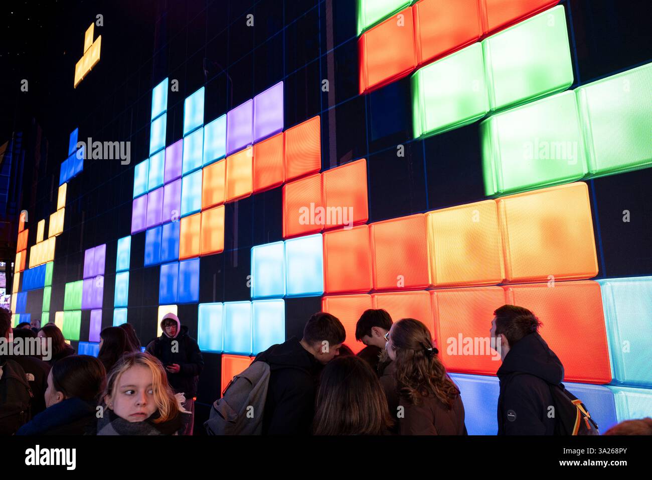 People interact with large scale digital screens displaying a giant ...
