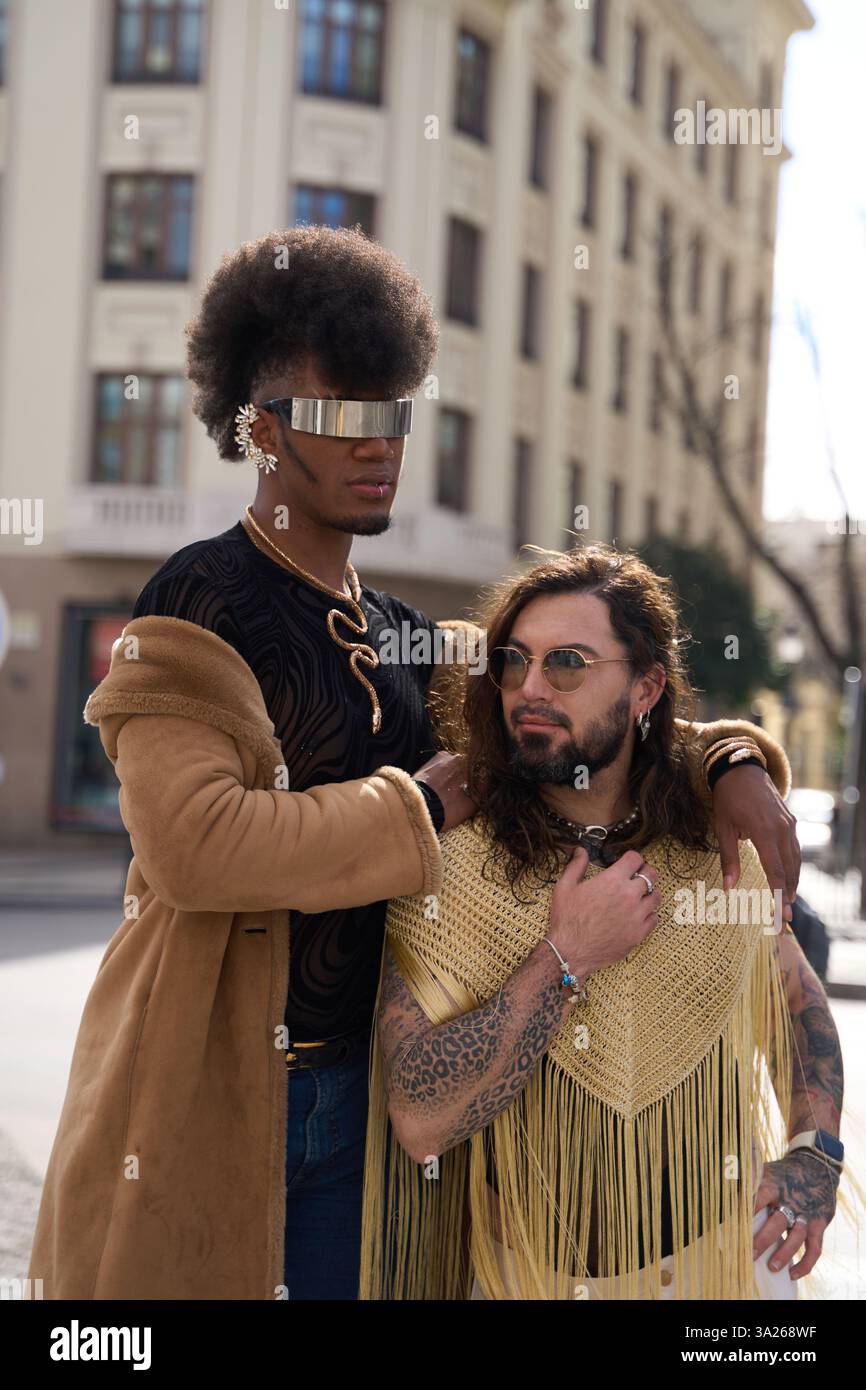 Two androgynous non binary people hugging each other in a city street ...