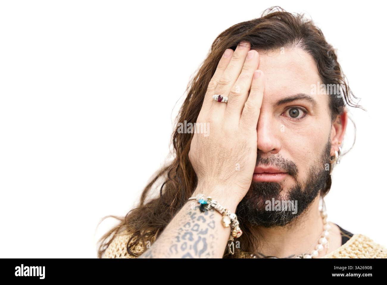 Portrait of a bearded latin transgender man with long hair covering his ...