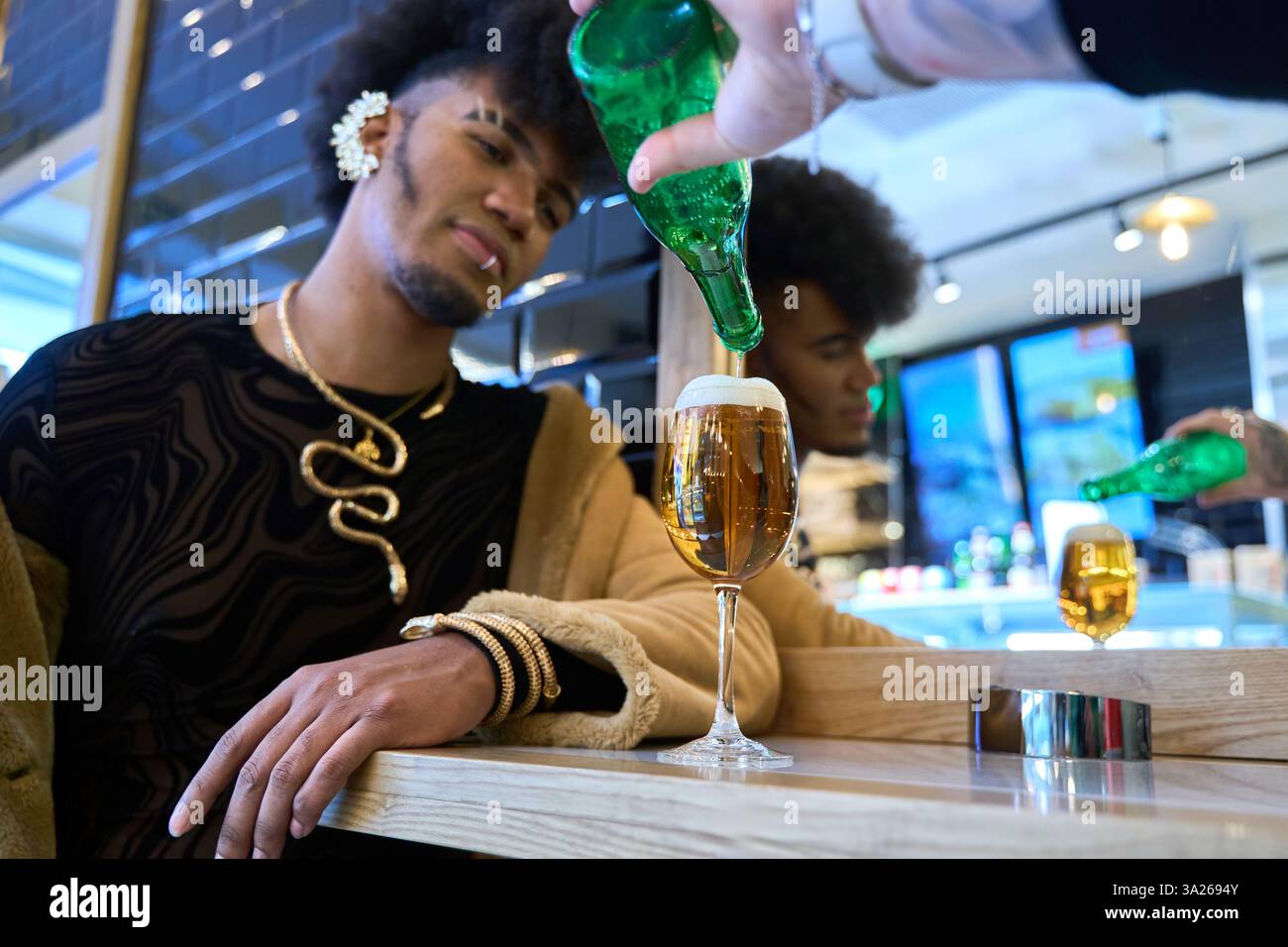 Bartender pouring beer into a glass for a stylish androgynous man ...