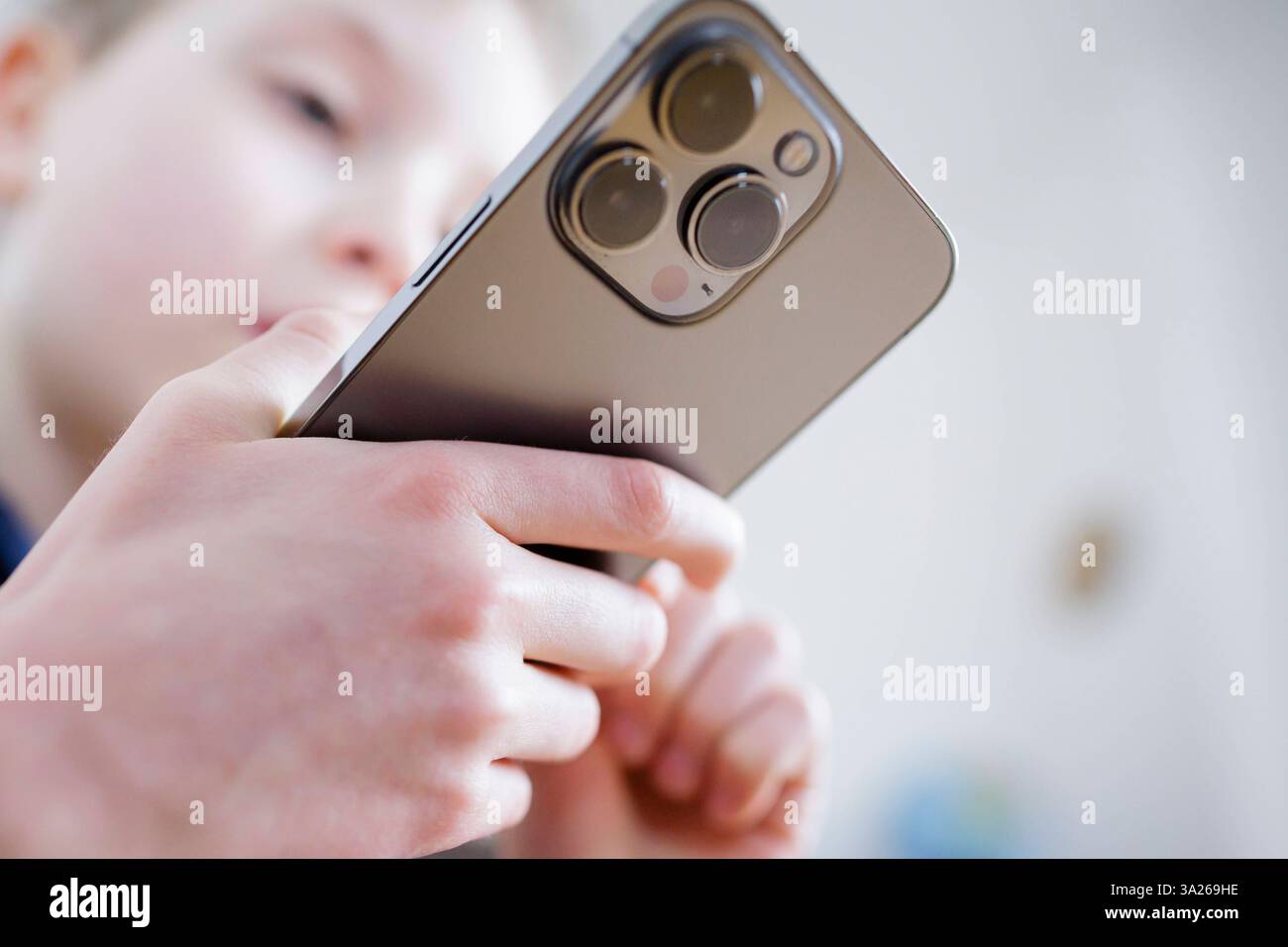 Symbolfoto zum Thema Handynutzung von Kindern. Ein Junge haelt ein ...