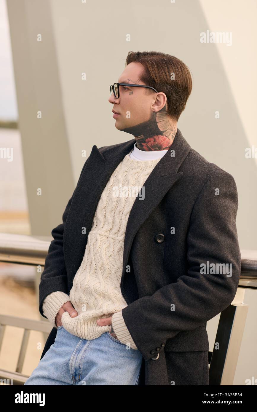 Handsome man poses confidently on a modern balcony, showcasing his ...