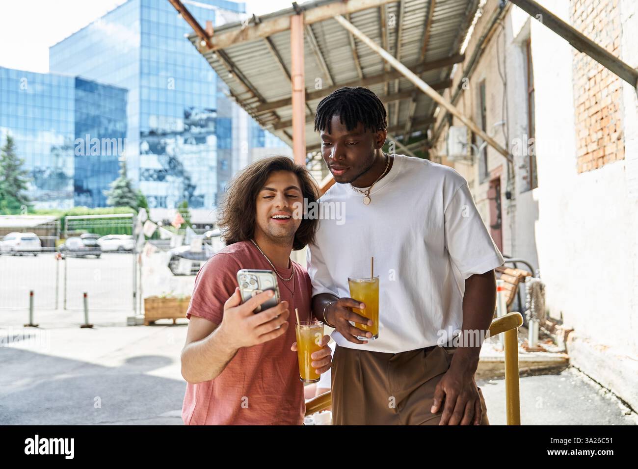 Two handsome men share a delightful moment in a cafe, smiling as they ...
