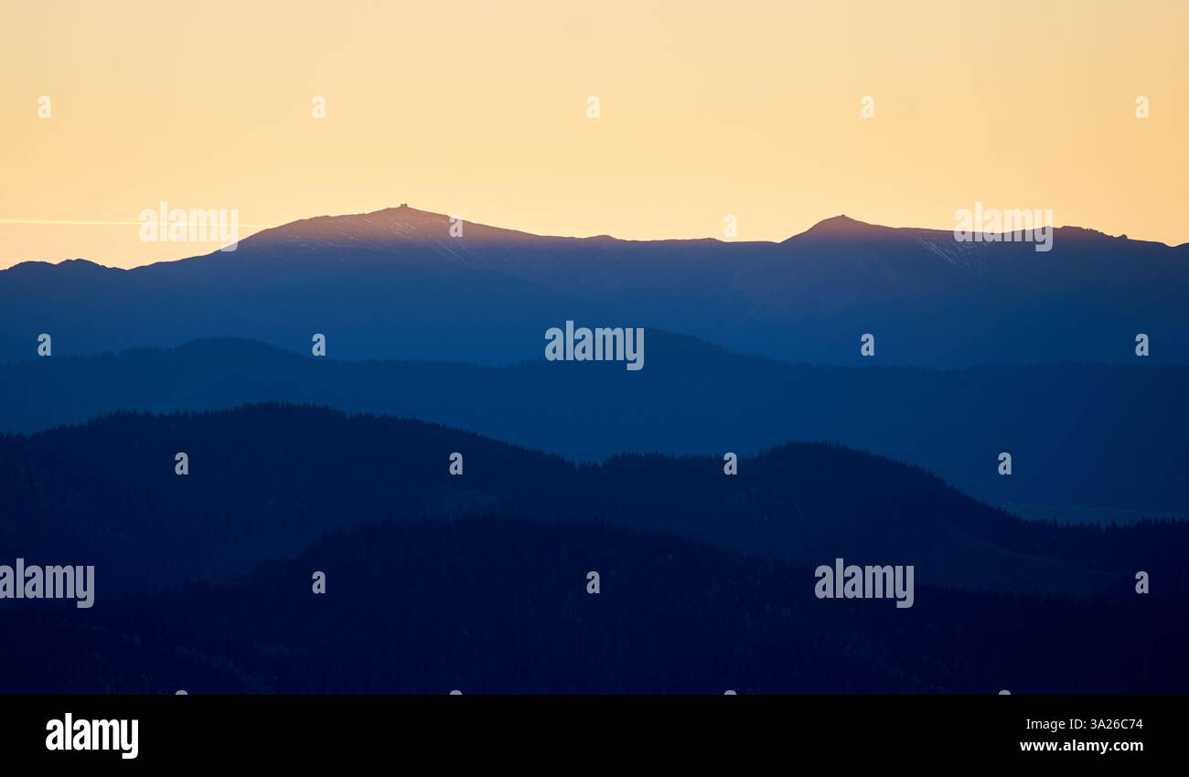 Silhouette of distant mountains at sunset, with golden sky ...