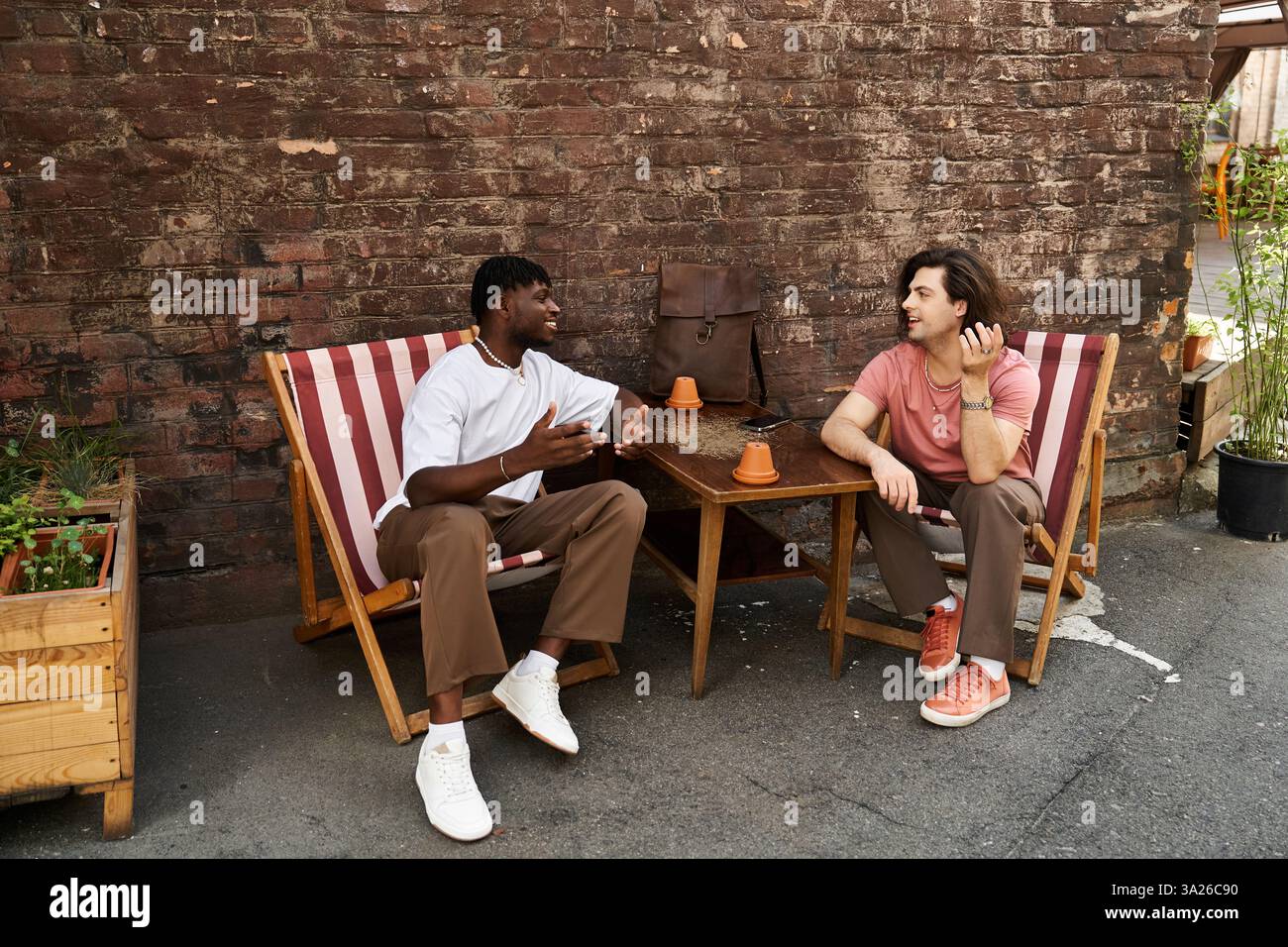 Two handsome men share laughter and conversation over coffee at an ...