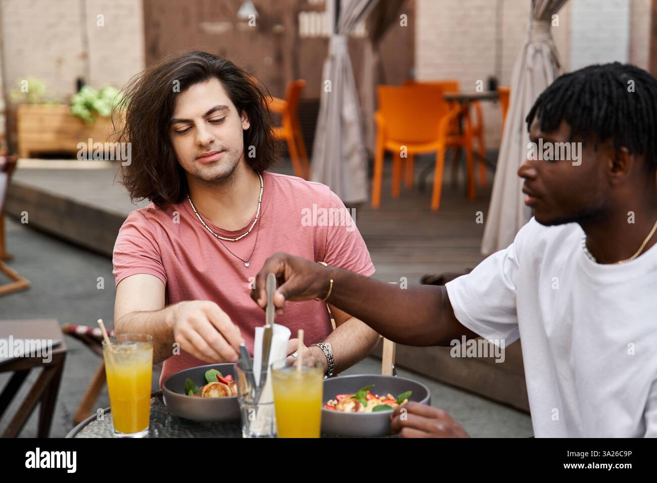 Two handsome men enjoy a delightful lunch date at a cozy cafe, sharing ...