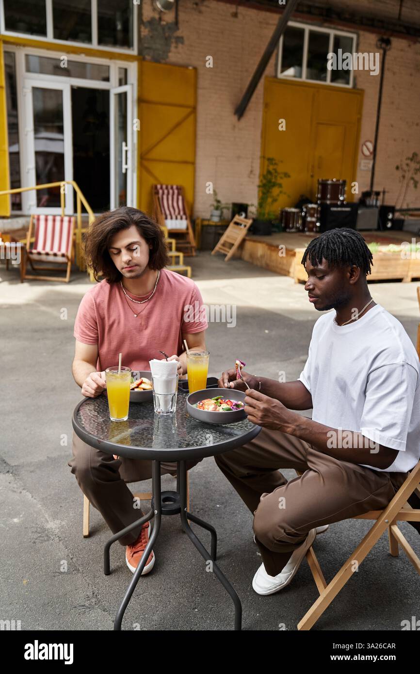 Two handsome men share a delightful meal and laughter at a quaint ...