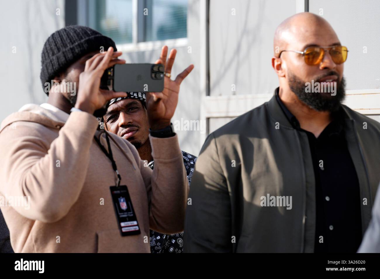 Retired NFL player T.J. Wright, second from left, watches footage on NFL player Charles Harris ...