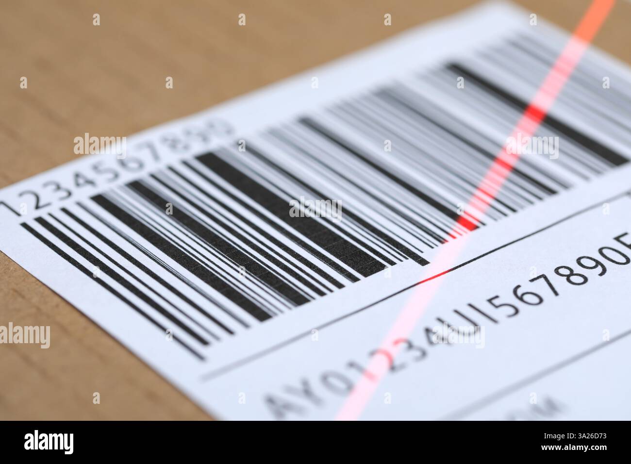 Parcel with label, closeup. Red laser light on barcode for scanning ...