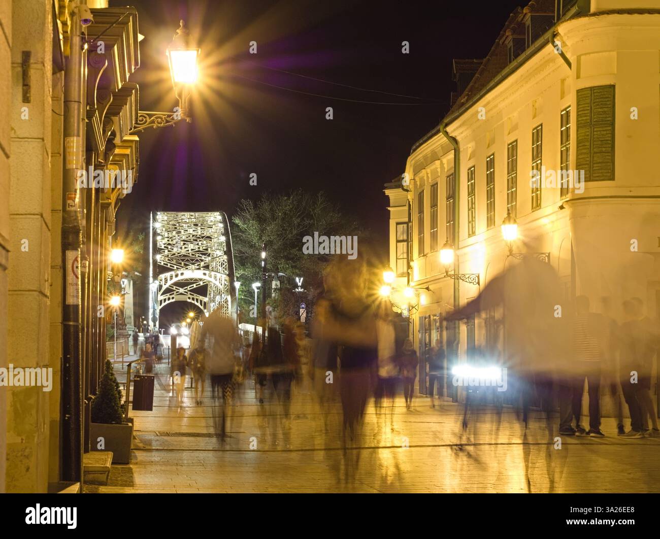 A lively evening scene on Jedlik Anyos Street in Gyor, Hungary with the ...