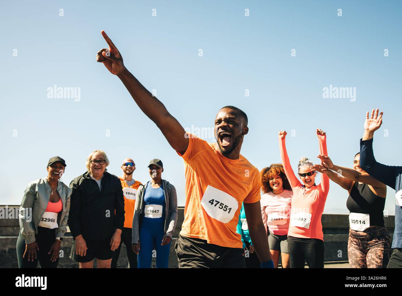 A diverse group of happy runners celebrate triumphantly at the finish ...