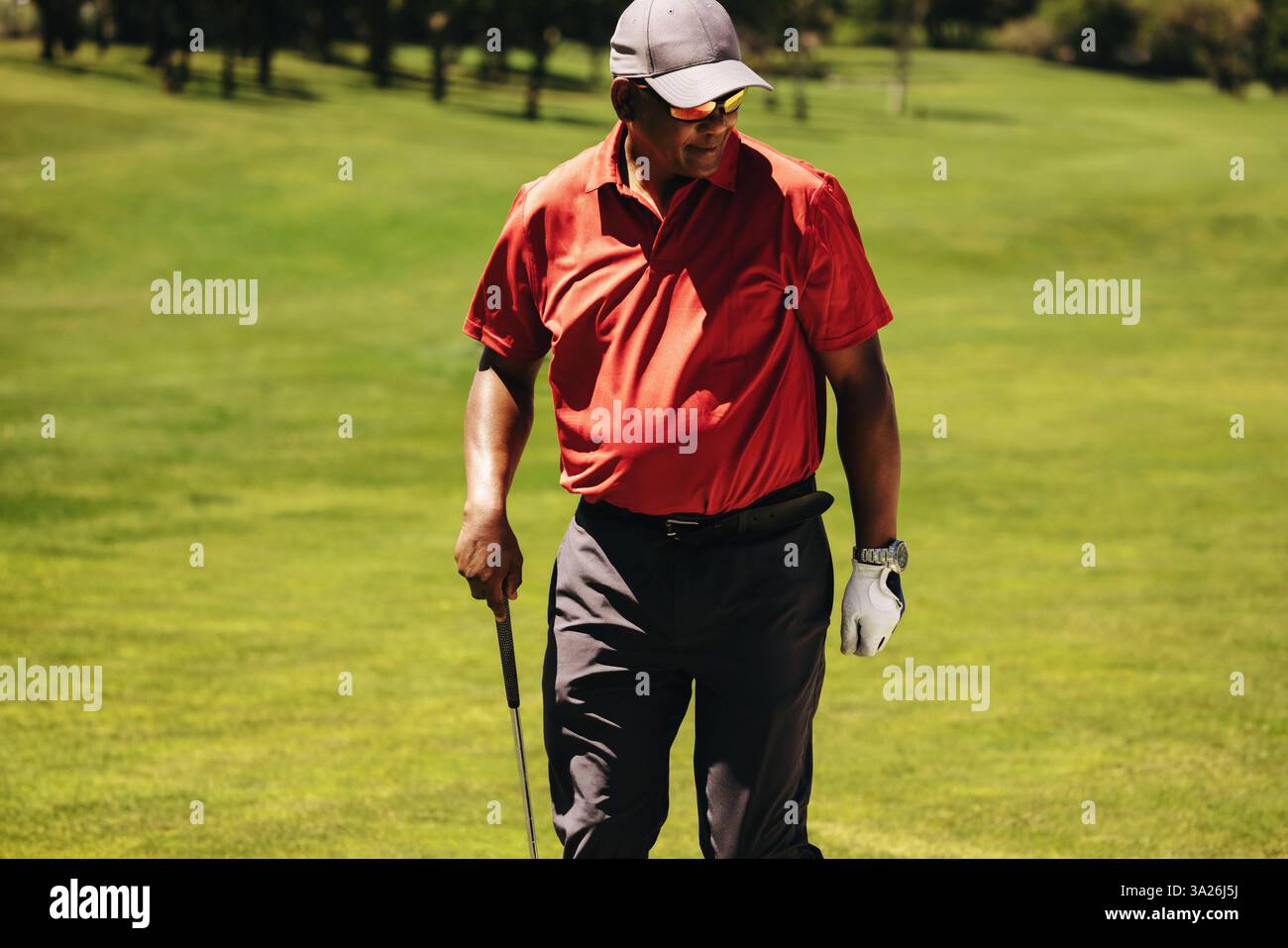 Golfer focused on strategizing the next shot from the rough, showcasing ...