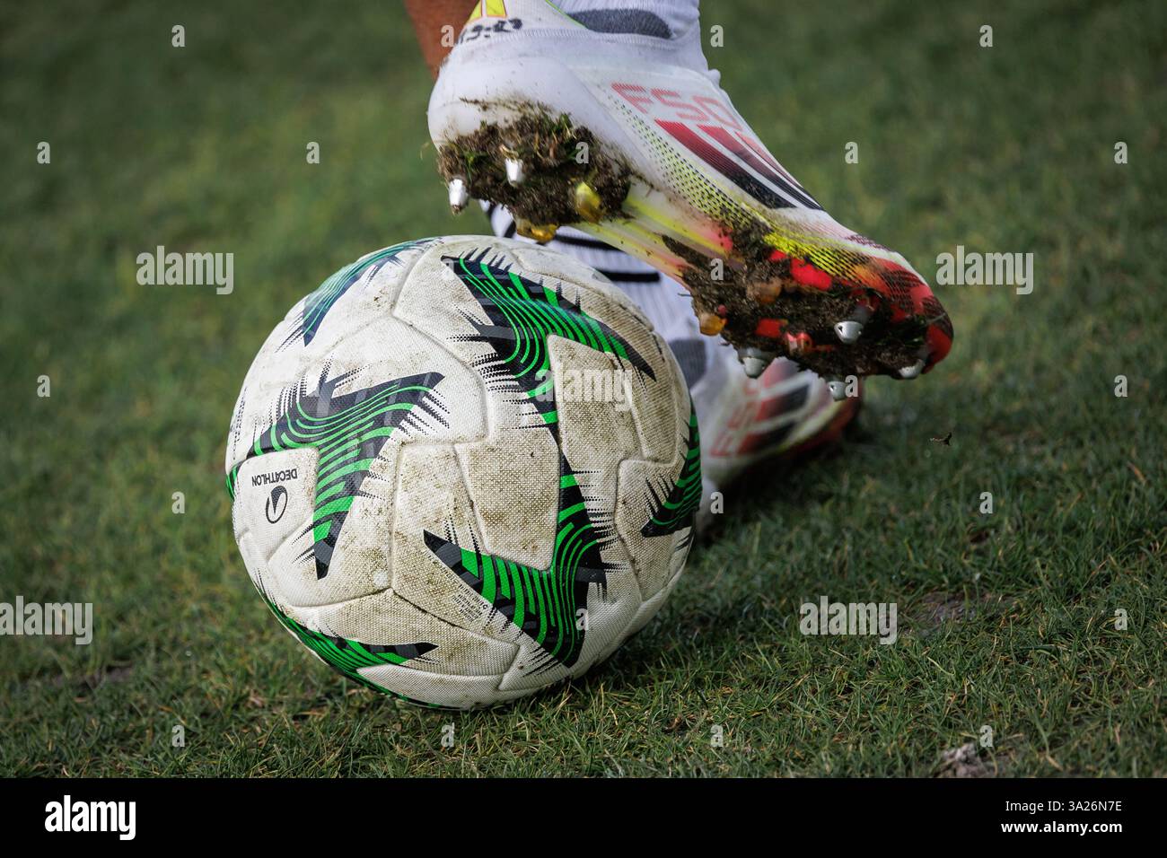 A close up on a feet with a soccer shoe with metal stads and a ball at ...