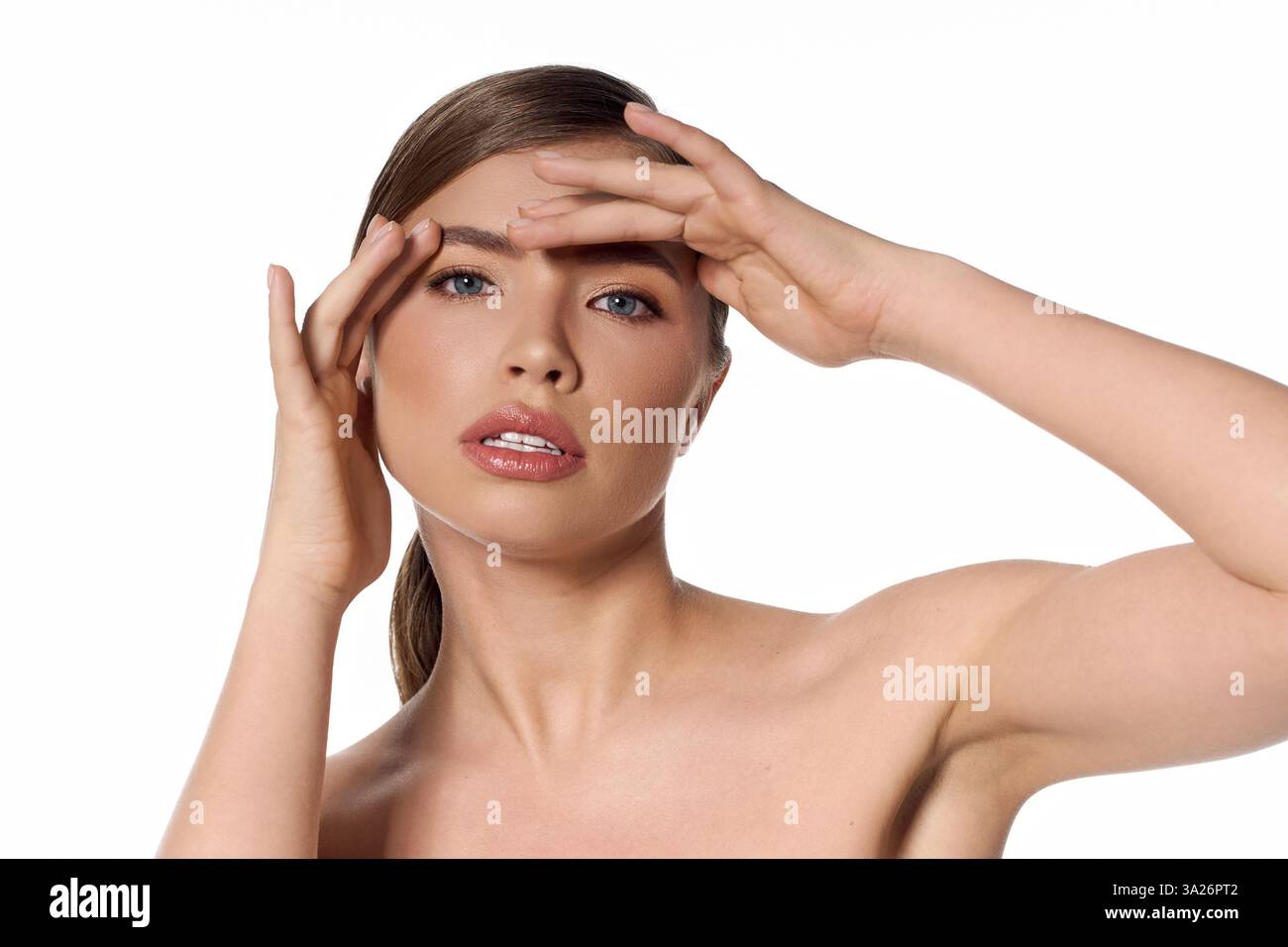 Beautiful young woman elegantly poses with her hand on her forehead ...