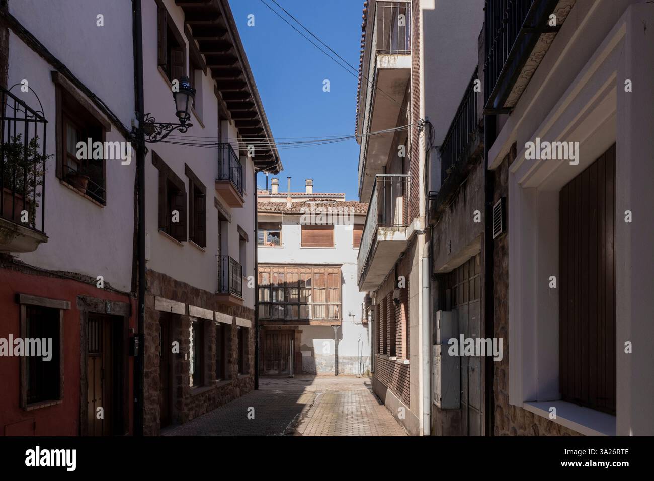 A narrow alley in a historic European town, lined with traditional and ...