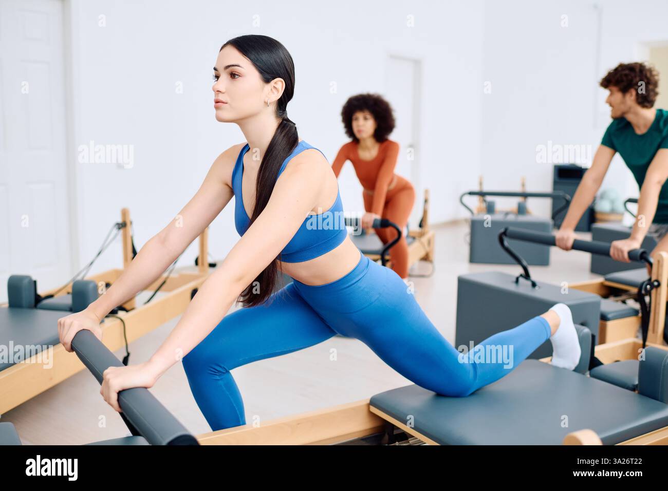 Participants engage in a challenging pilates workout, enhancing ...