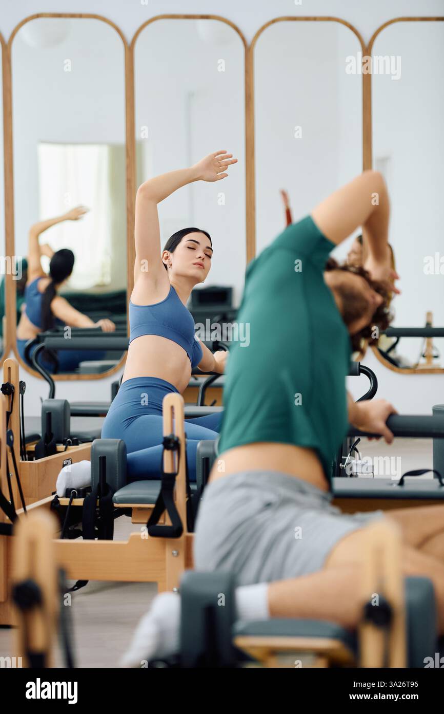 Two individuals engage in a challenging pilates session to boost ...