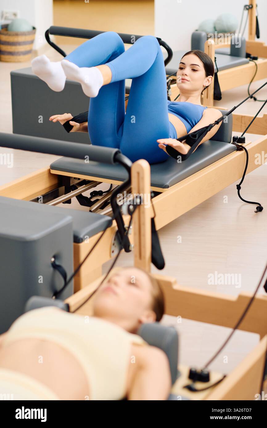 Two individuals practice pilates, showcasing strength and concentration ...