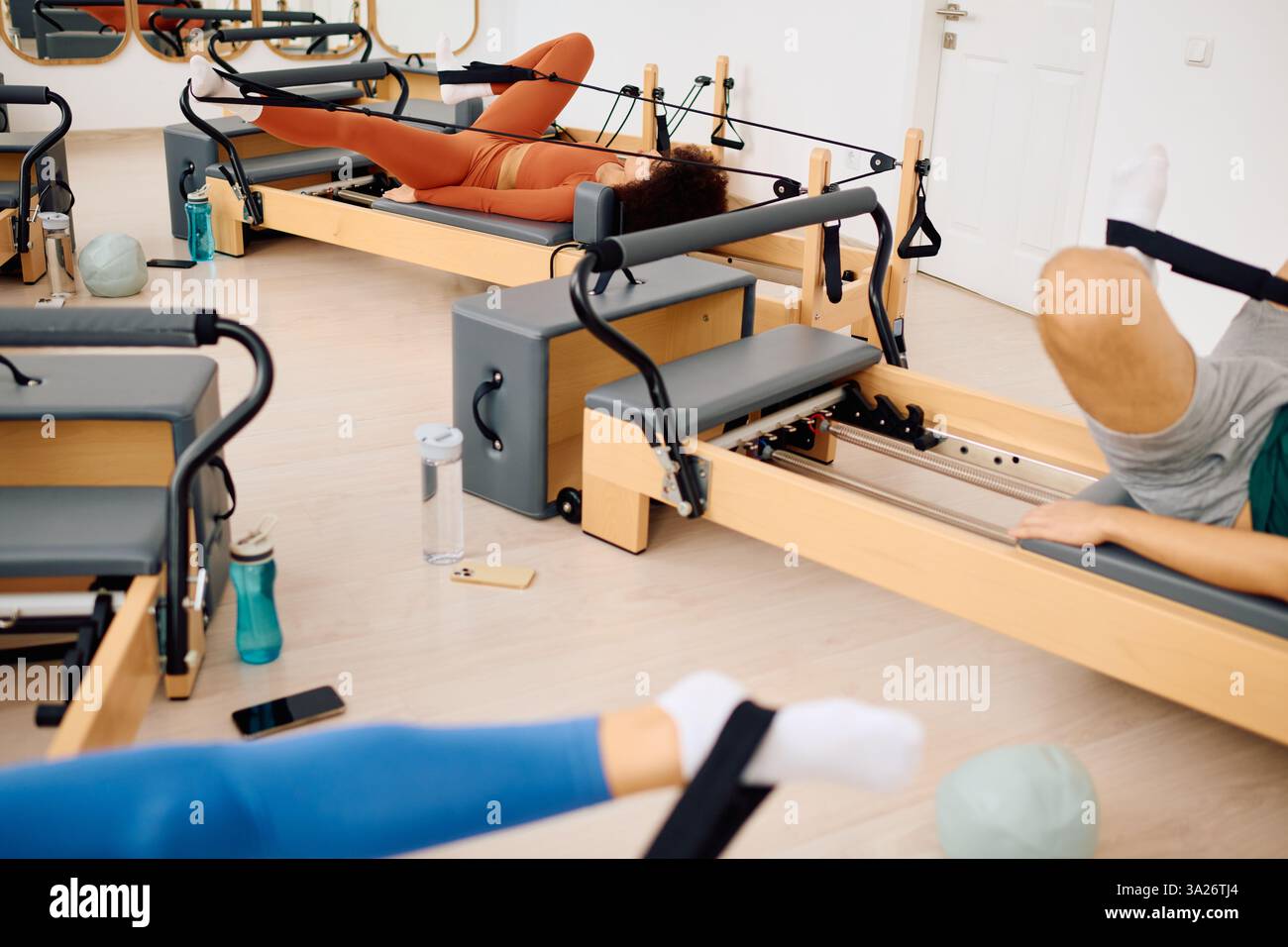 A group takes a tough pilates class with reformer machines for strength ...