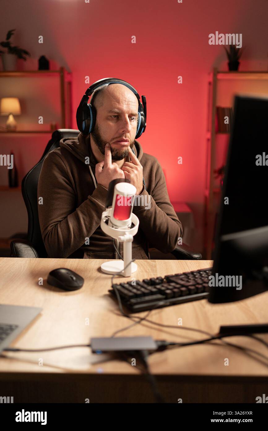 Sad bearded man playing online computer video game, broadcast streaming ...