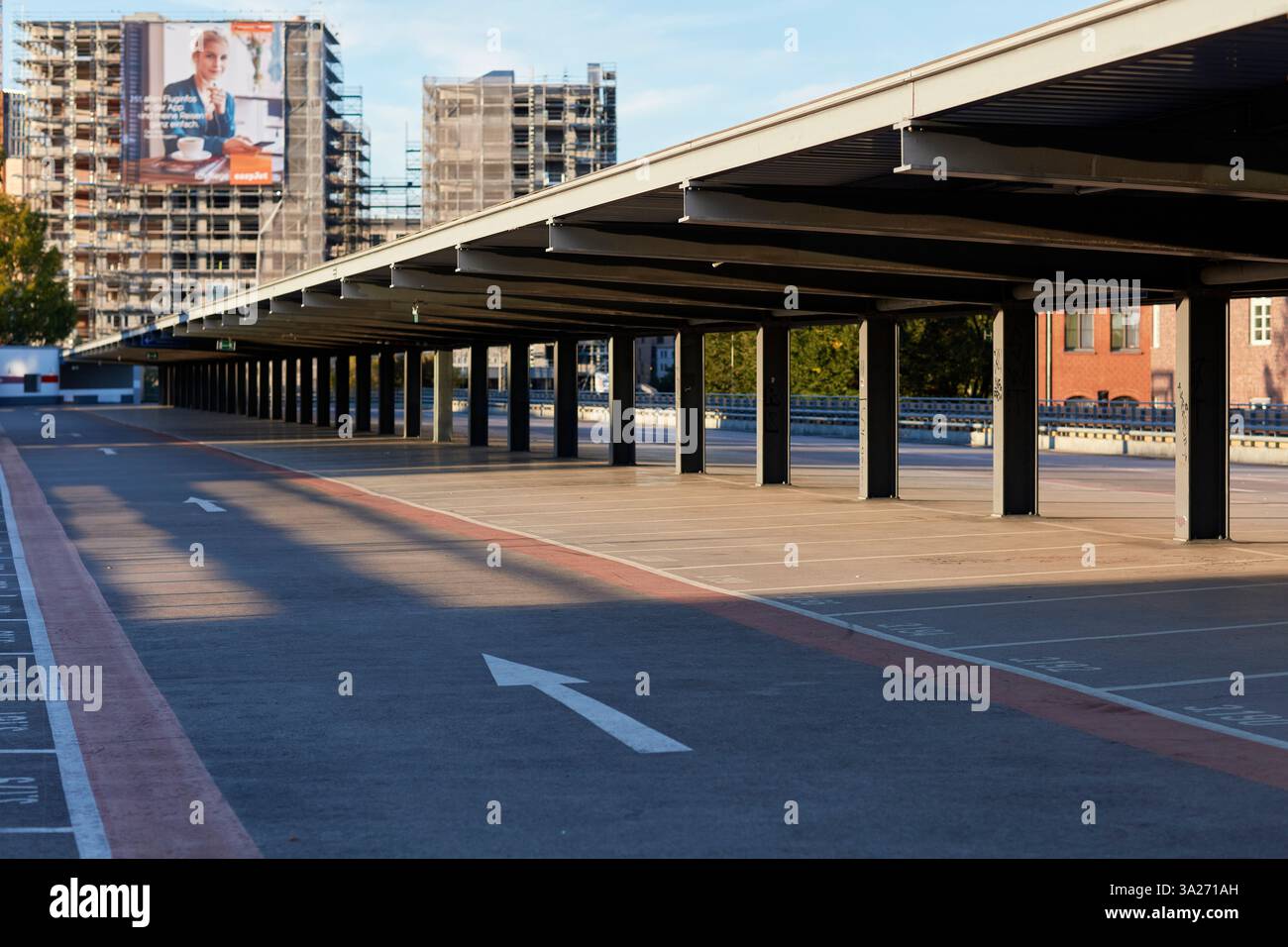 Empty rooftop parking deck with metal beams and city buildings in the ...