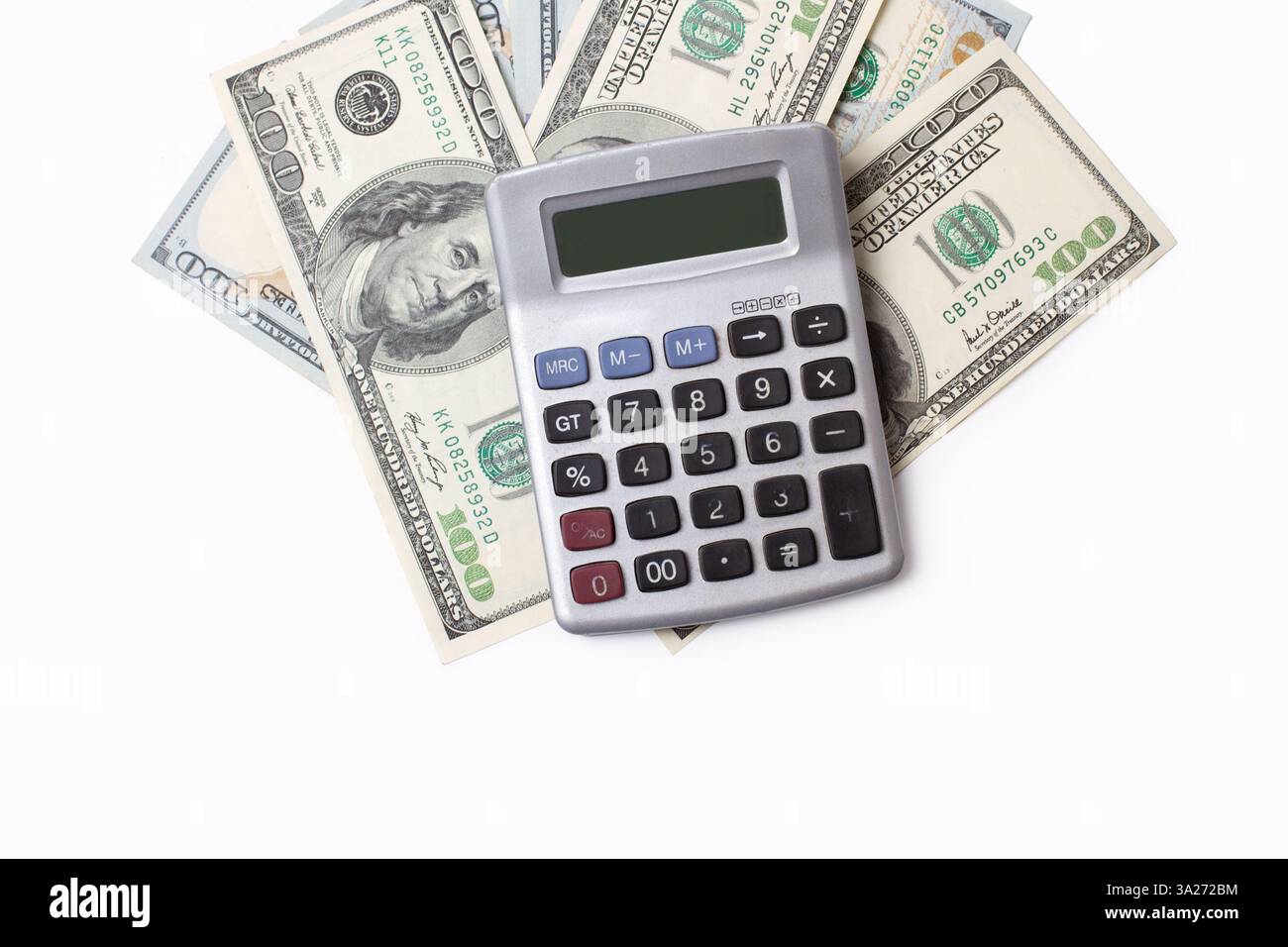 One hundred dollar bills and a vintage calculator on a white background ...