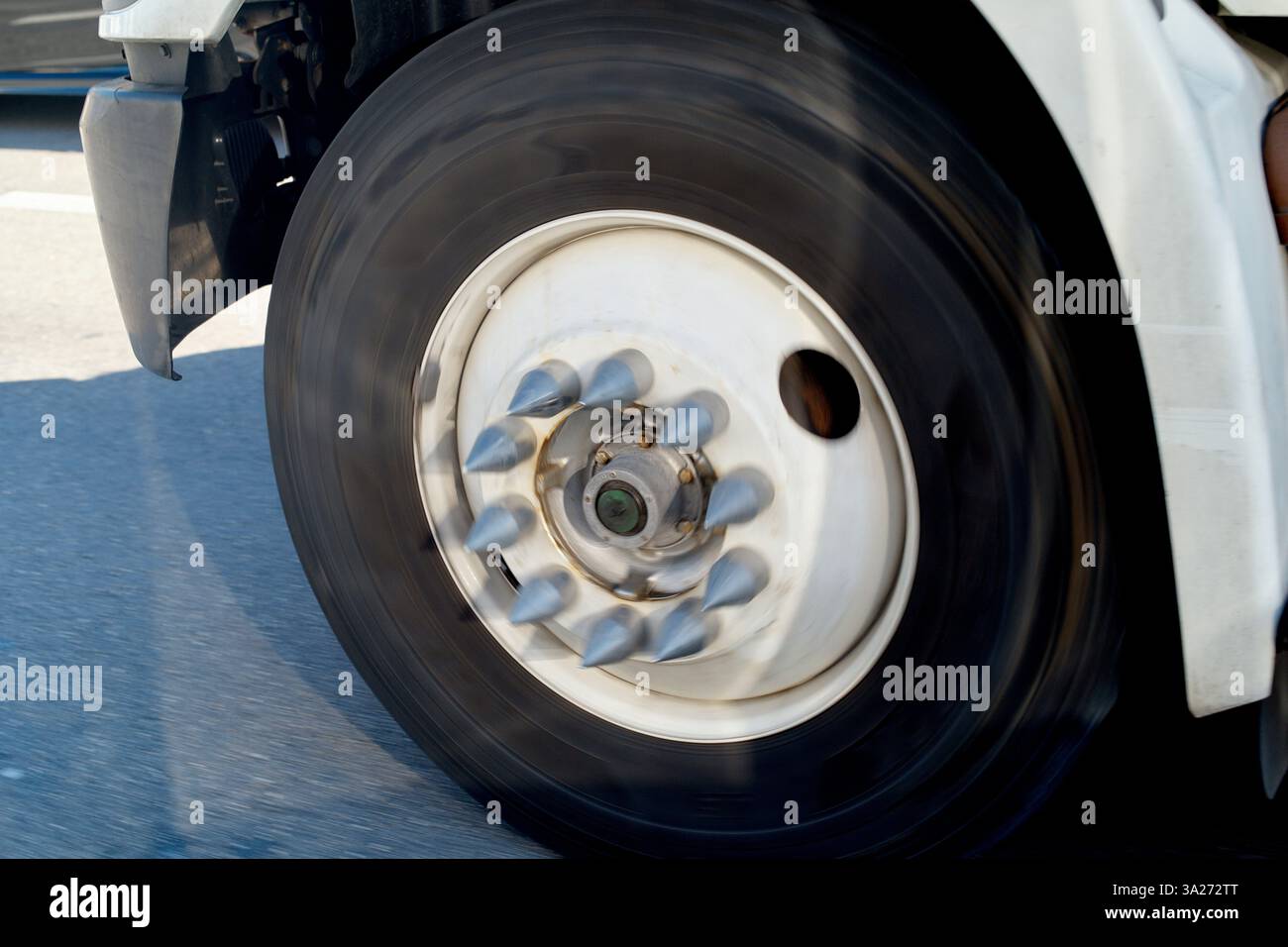 Close-up of a spinning truck wheel in motion on a sunny day on the road ...