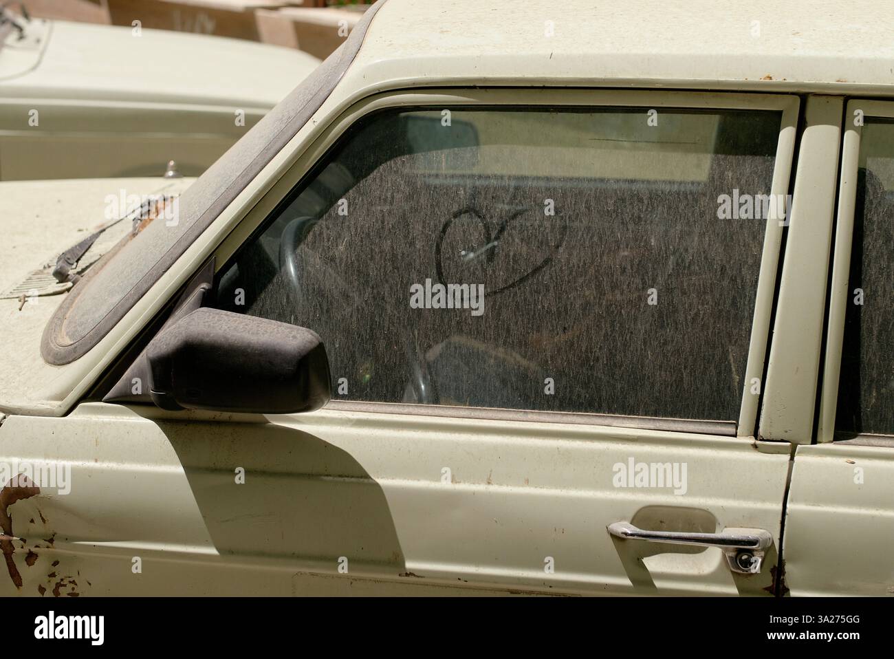 An old dusty car window with a heart drawn into the dirt on the glass ...