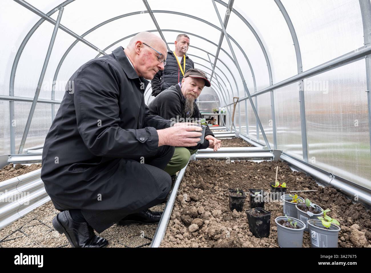 First Minister of Scotland John Swinney (front) is shown some seedlings ...