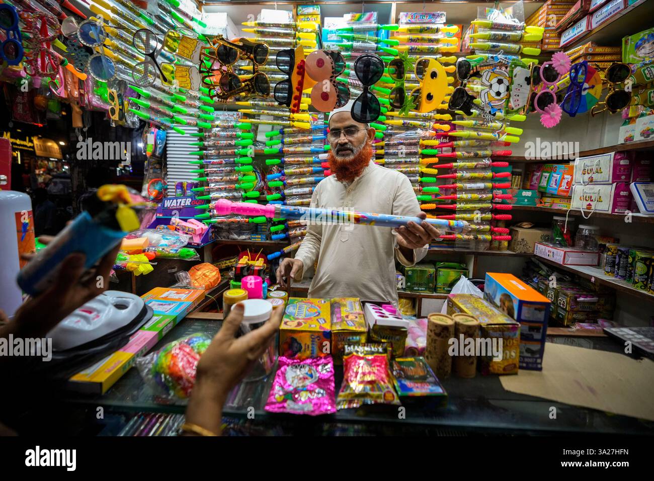 A vendor sells water guns and color powder ahead of Holi festival in ...