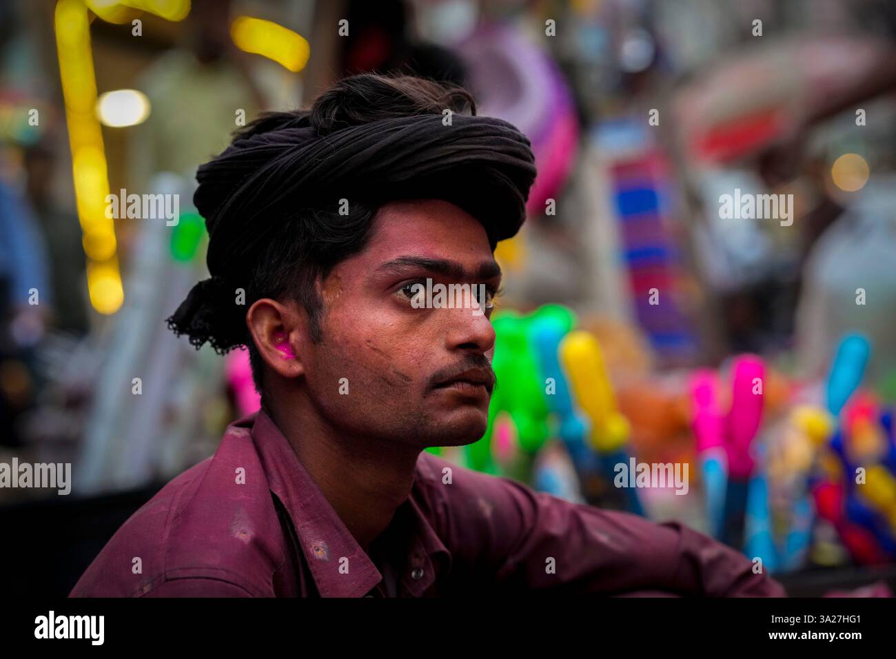 A street vendor waits to sell color powder ahead of Holi festival in ...