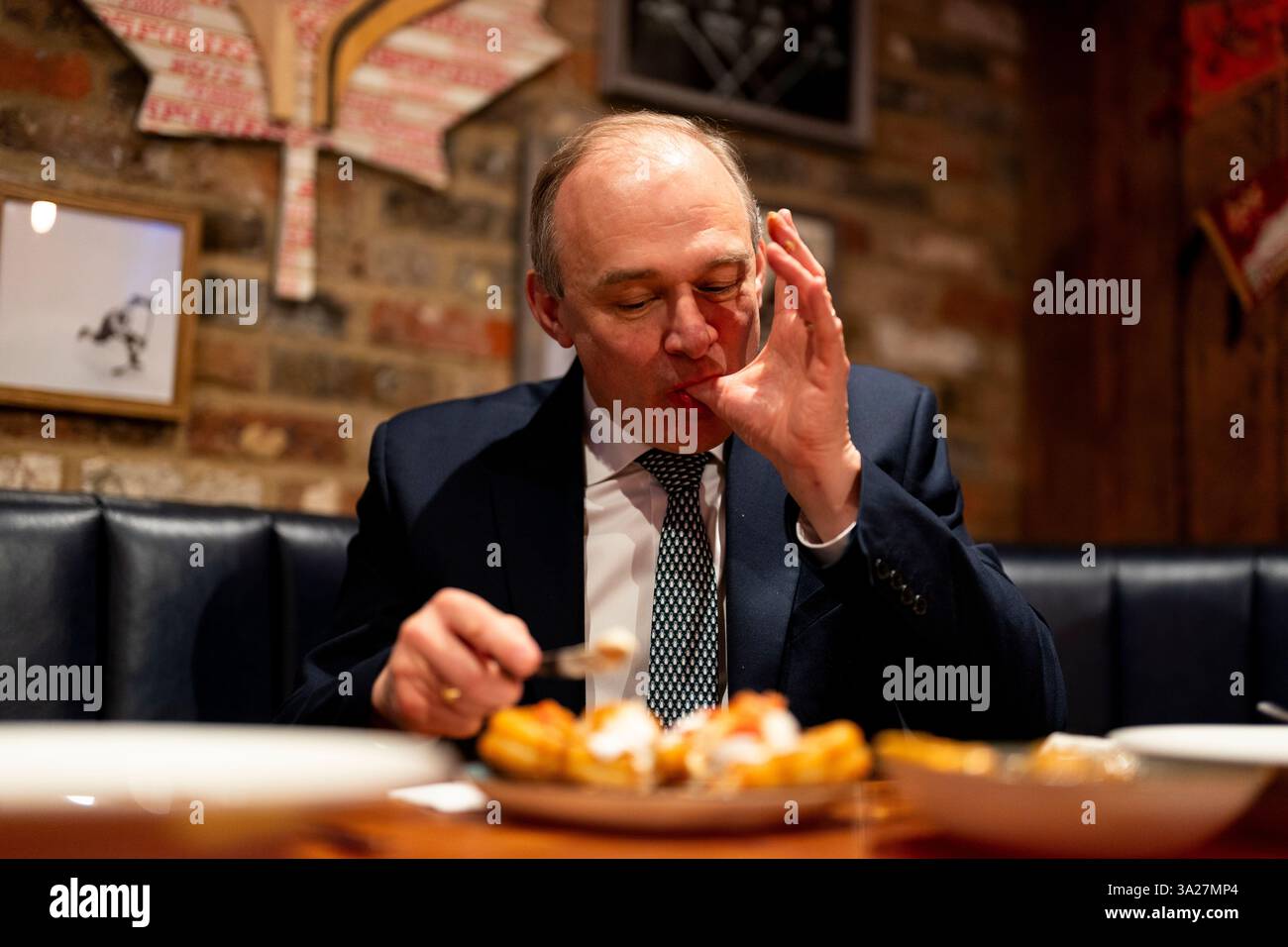 Liberal Democrats leader Sir Ed Davey, eats some food at the Canadian ...