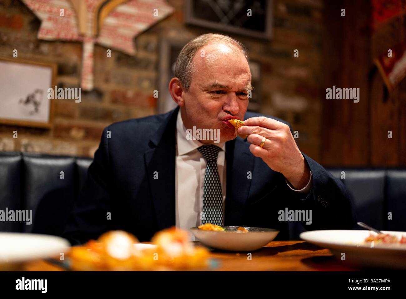 Liberal Democrats leader Sir Ed Davey, eats some food at the Canadian ...