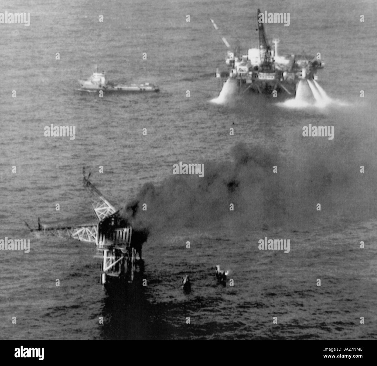Smoke rises from the wrecked oil platform Piper Alpha, foreground, in ...