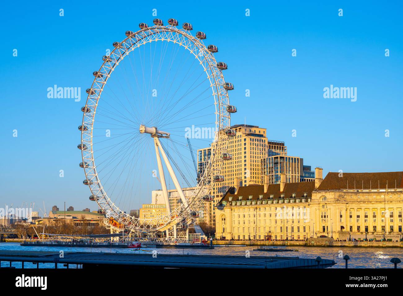 A large observation wheel stands tall against a clear blue sky ...