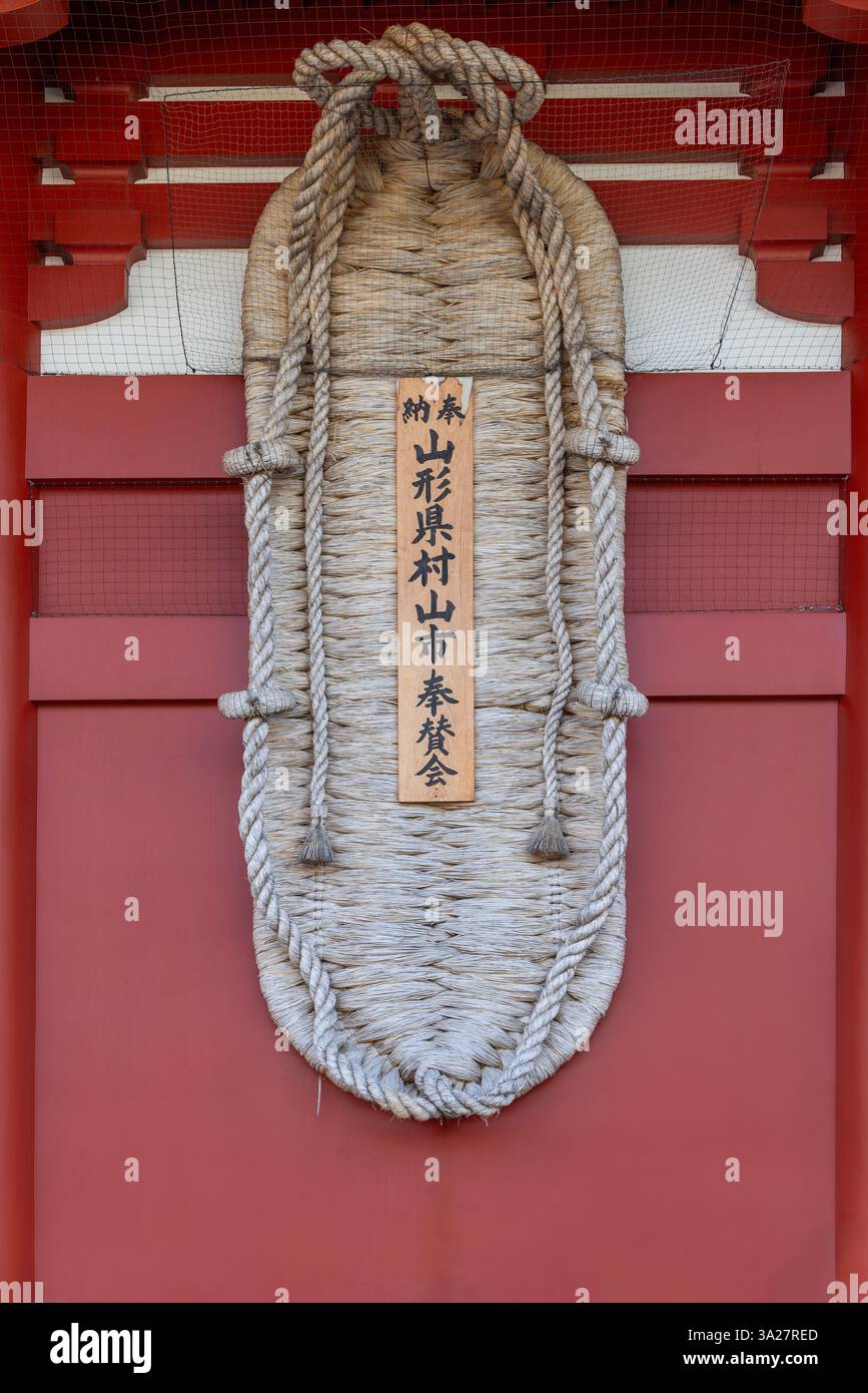 Woven straw sandals waraji are displayed on the red wall of Senso-ji ...