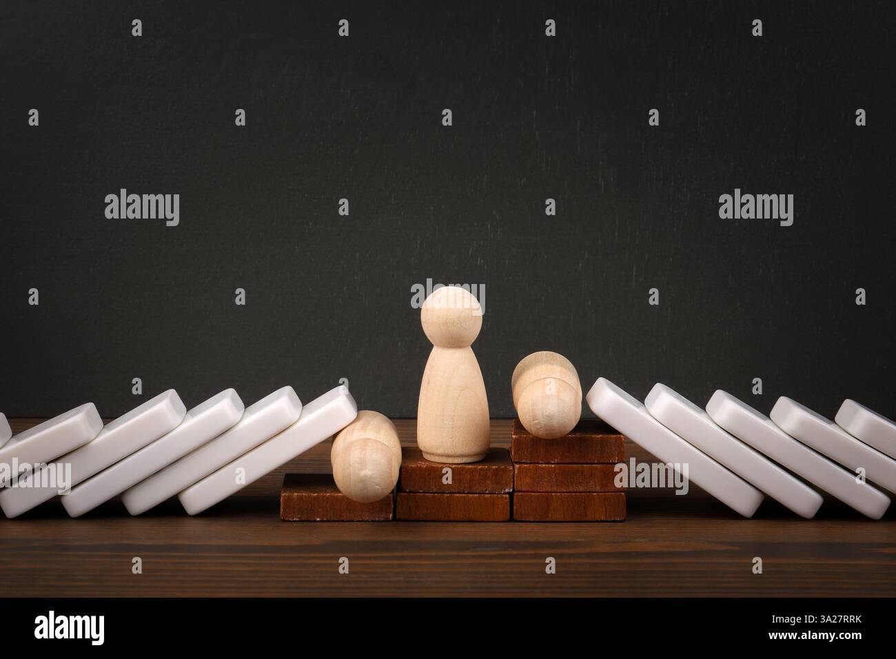 Fallen dominoes and human figures. Competition concept Stock Photo - Alamy