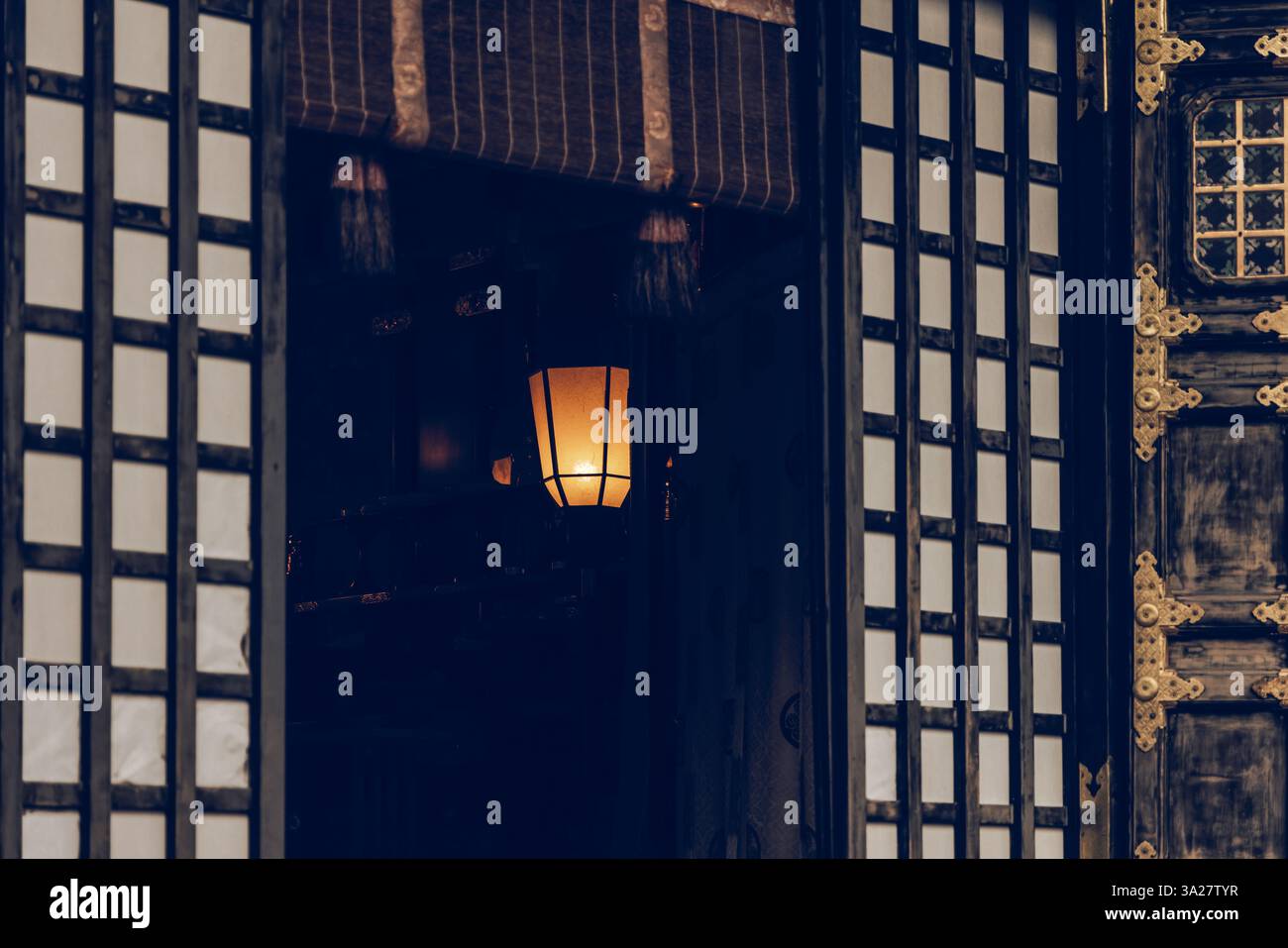 Soft lantern light illuminating the dim interior of a Japanese temple ...