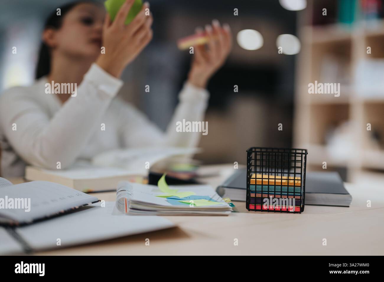 Focused woman studying with colorful sticky notes in library Stock ...