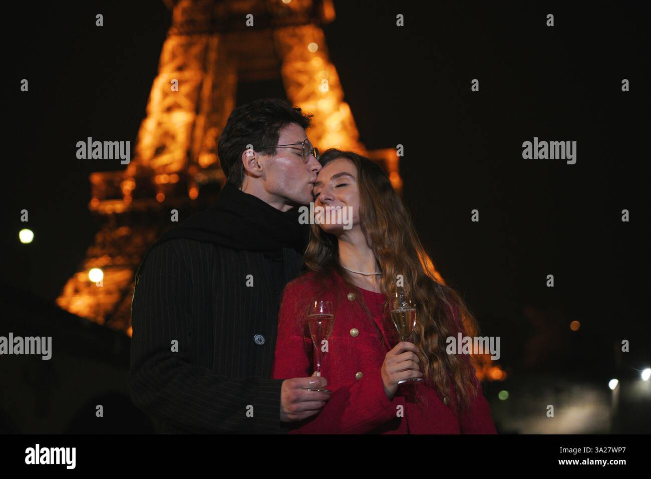 A romantic couple enjoys a tender moment with champagne under the ...