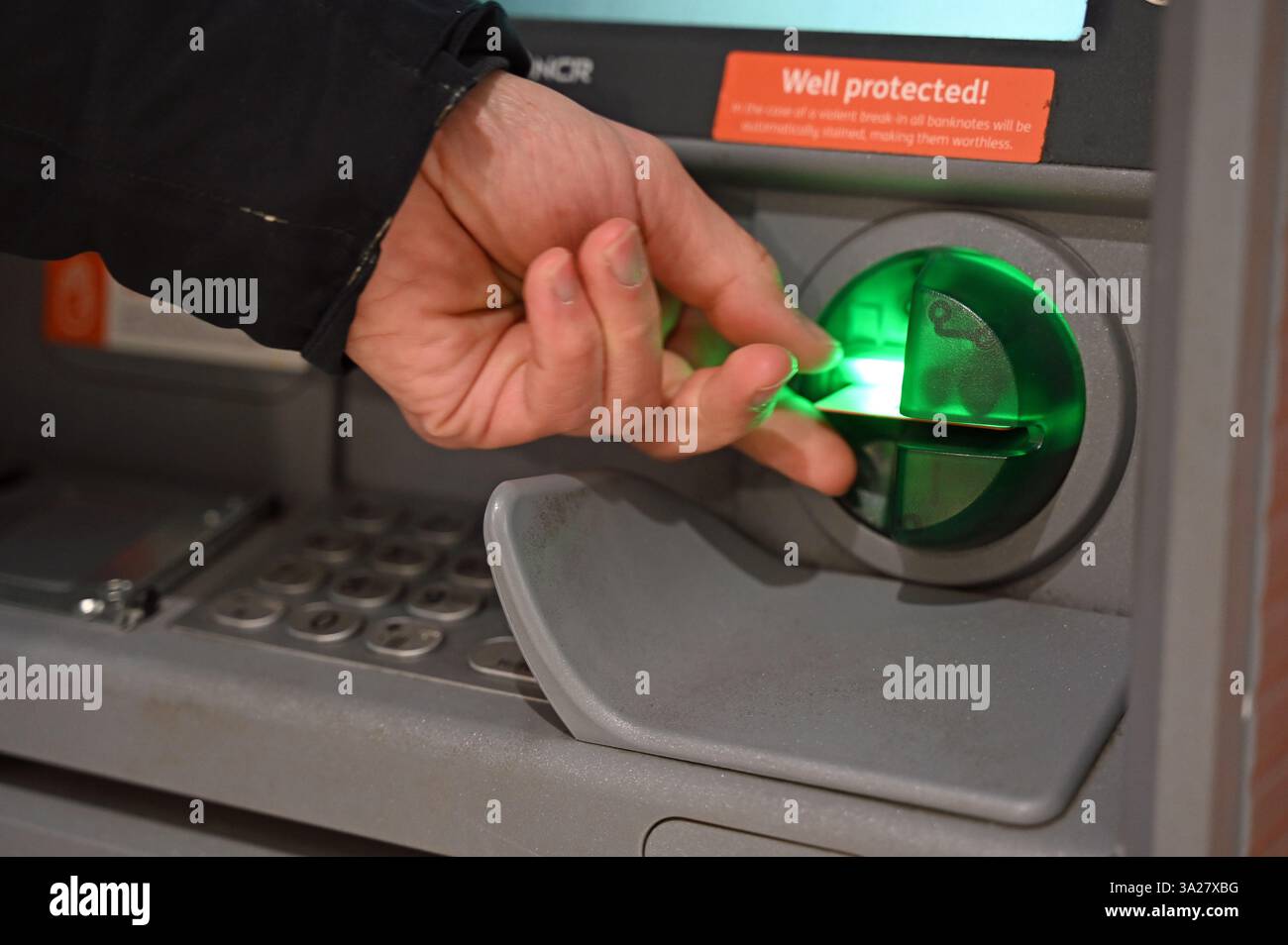 Leipzig, Germany. 12th Mar, 2025. A man pulls his bank card out of the ...