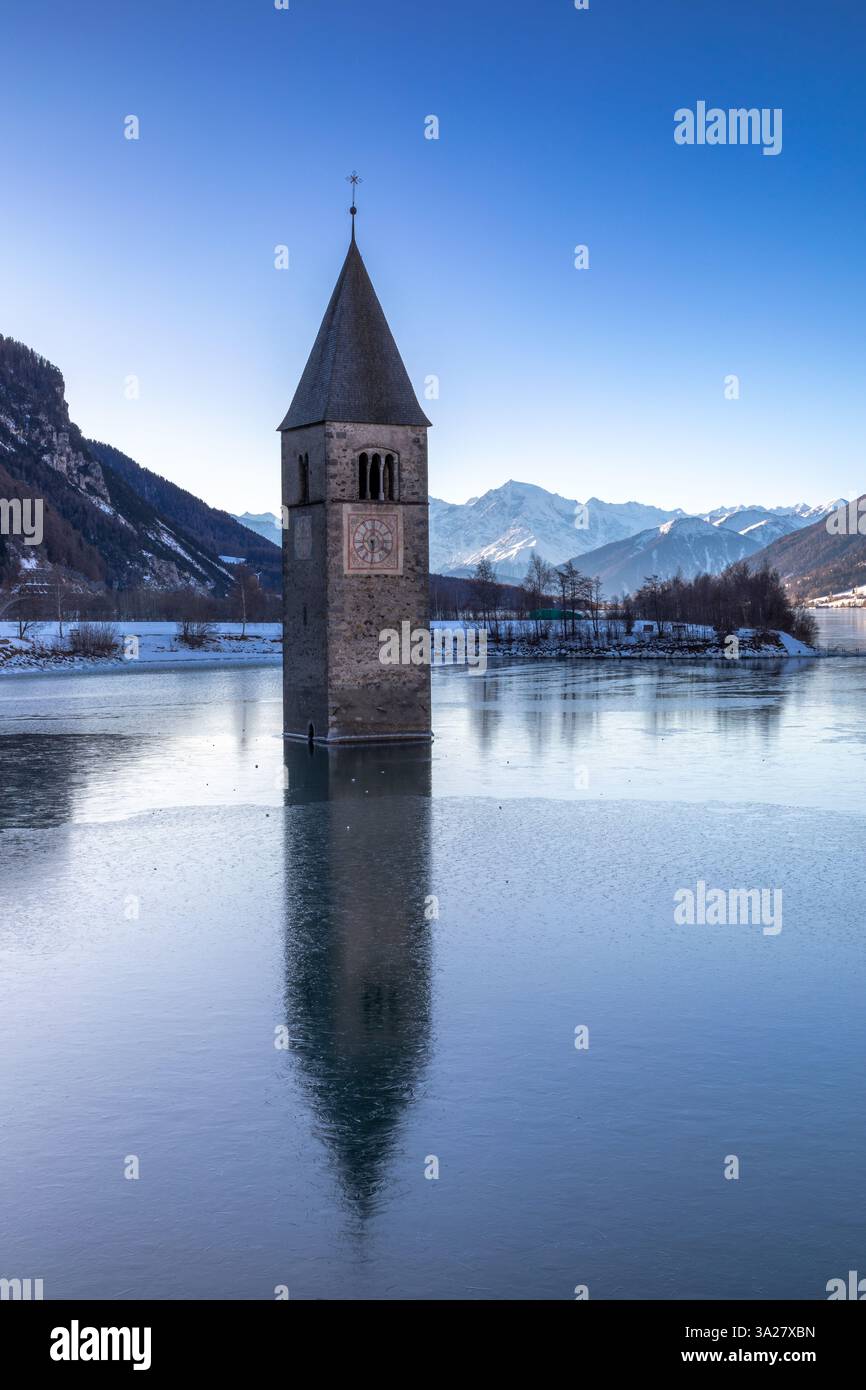 Steeple of Old Curon in frozen lake Reschensee, South Tyrol, Italy ...