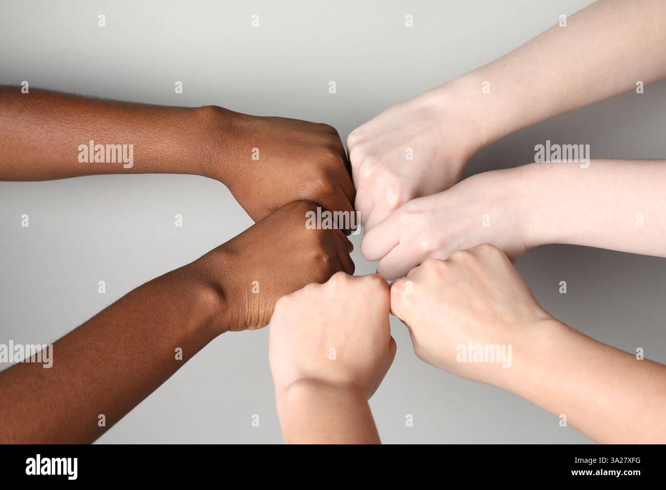 Stop racism. People of different skin colors bumping fists on light ...