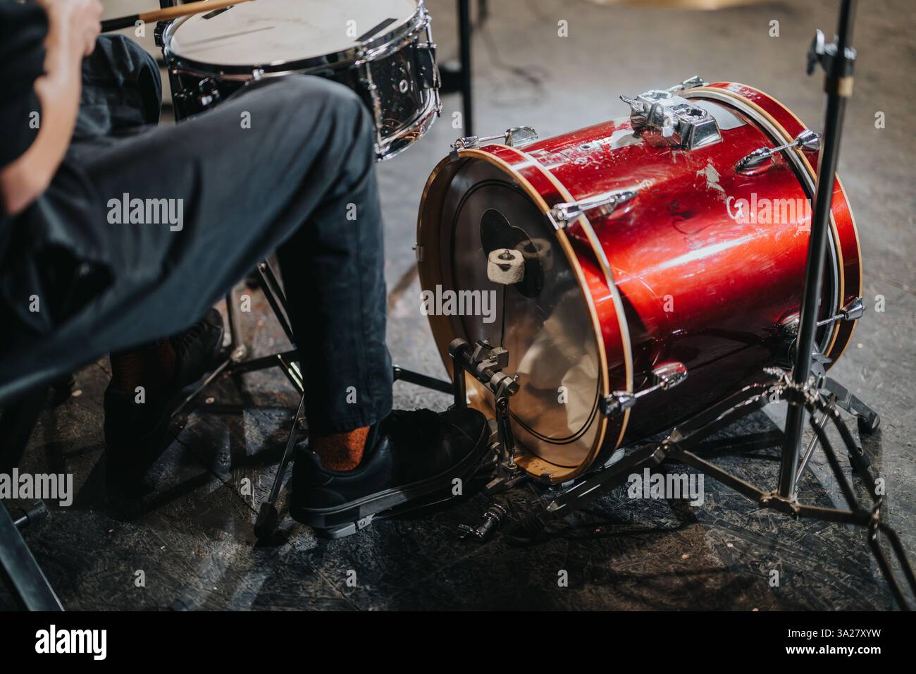 A detailed view showing a drummer's foot at a drum set during a ...