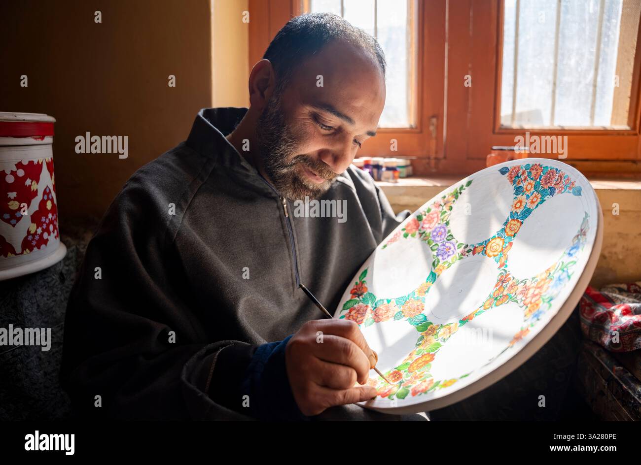 Mir Arshad Hussain seen working on a papier-mâché item at his home-based workshop. Mir Arshad ...