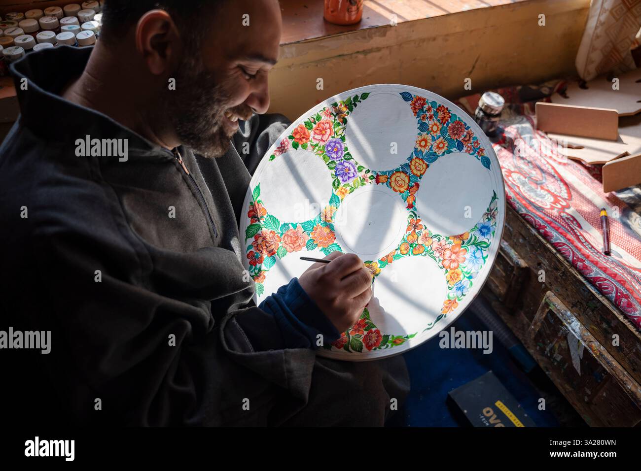 Mir Arshad Hussain seen working on a papier-mâché item at his home-based workshop. Mir Arshad ...