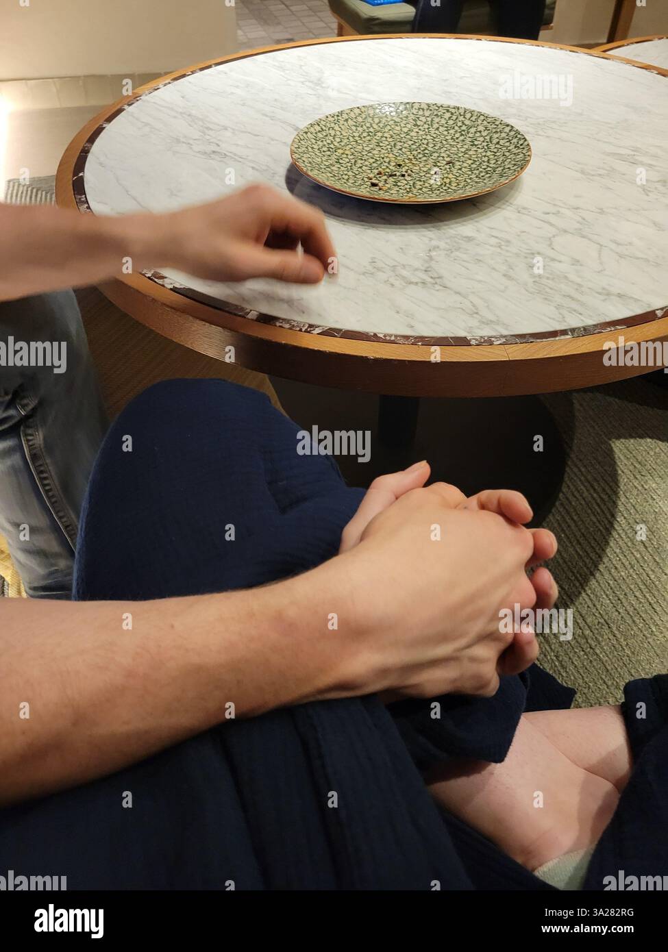 A person stands with hands together, observing their reflection Stock ...