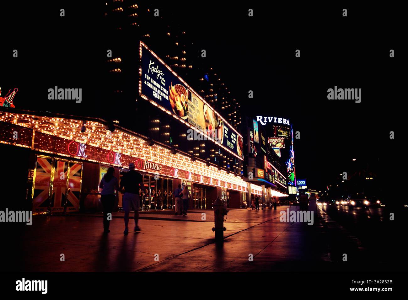 A vibrant night scene of the Riviera Hotel in Las Vegas, featuring ...
