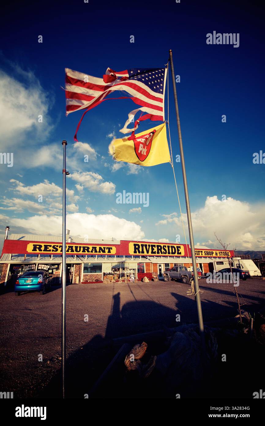 A vibrant scene featuring a restaurant named 'Riverside' with flags ...