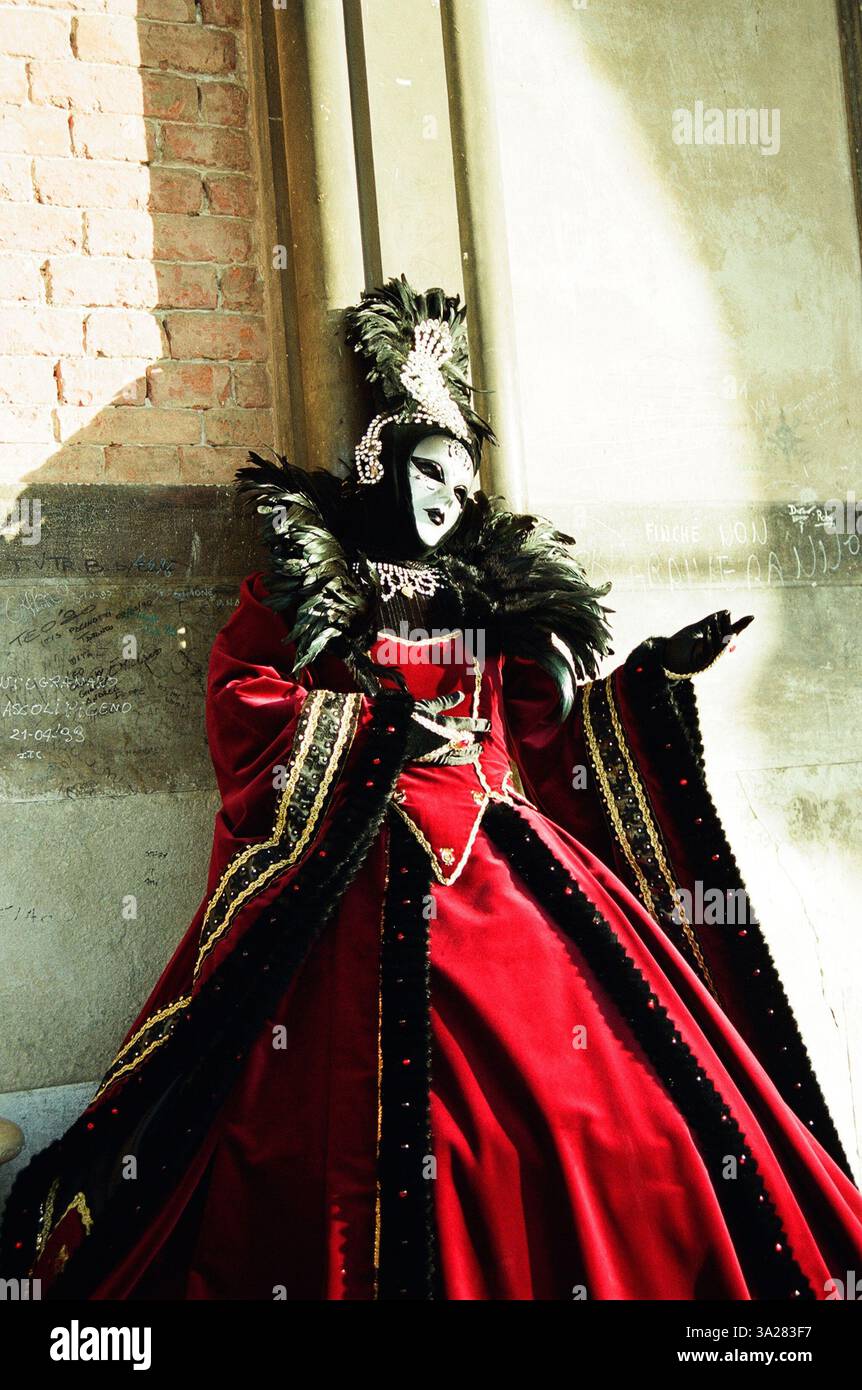 A person in an elaborate red and black costume with feathers and ...